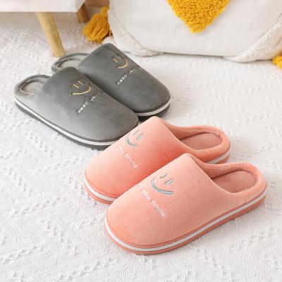 China Hot selling 2021 new fashion soft plush winter slippers smile patterns vamp non-slip couple home shoes in stock for sale