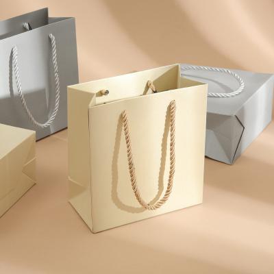 China Custom Logo Printed Gift Bags White Cardstock Coated Paper 24x10x17cm with Rope Handles for sale