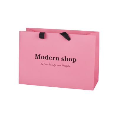 China Pink 250g Coated Paper Bags Packaging Clothing With Ribbon Handle for sale